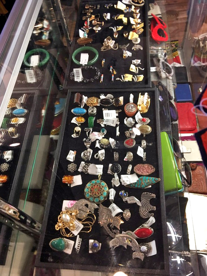 Vintage rings and brooches sparkle under glass, each tiny treasure waiting for the right finger or lapel to bring it back into the spotlight.