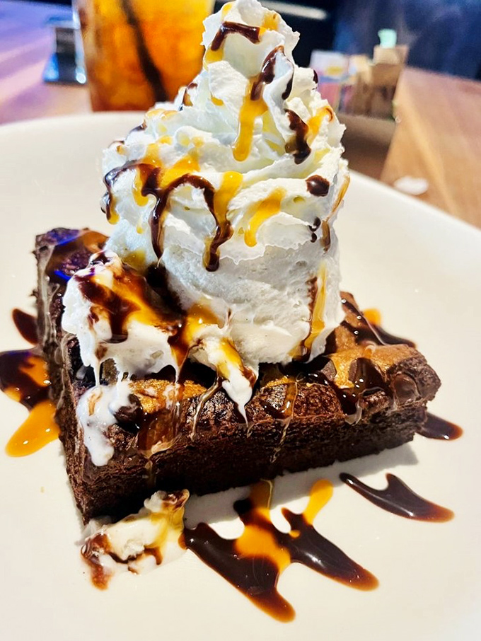 A brownie supporting the weight of ice cream, caramel, and chocolate sauce&mdash;the Atlas of the dessert world, carrying sweetness on its shoulders.