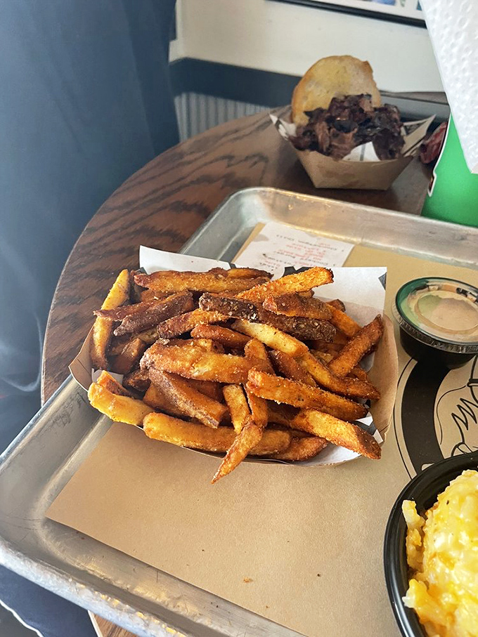 Fries that have clearly earned their PhD in crispiness, served alongside what appears to be pulled meat and mac and cheese&mdash;the holy trinity of comfort.