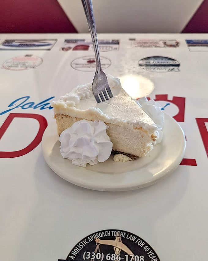 Cheesecake so light it practically hovers above the plate. That dollop of whipped cream isn't decoration &ndash; it's the exclamation point on a perfect dessert sentence.
