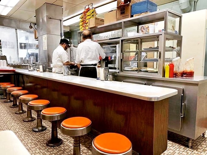 The counter where dreams come true, one coney at a time. Those orange stools have supported the weight of Detroit's greatest decisions.