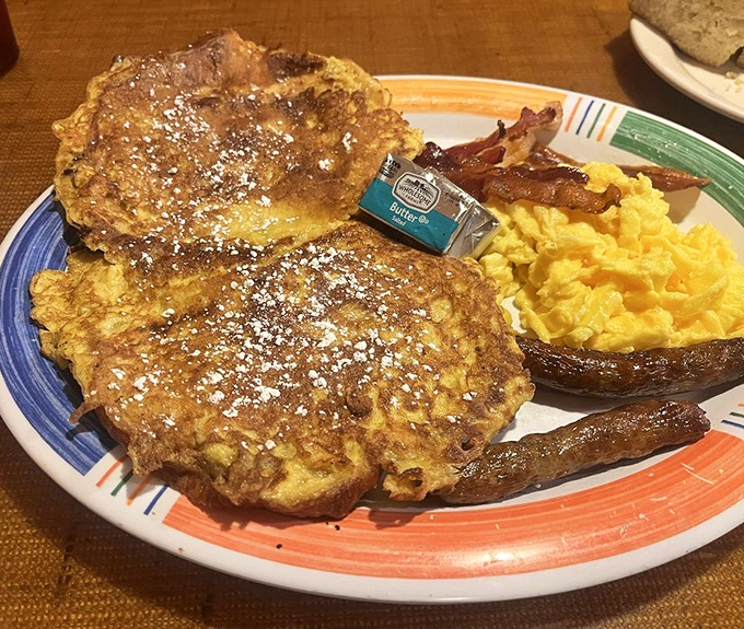 French toast that clearly went to finishing school. Powdered sugar, perfectly scrambled eggs, and bacon that knows its purpose in life.