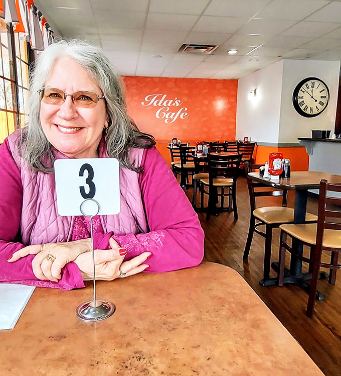 The warm orange accent wall creates the perfect backdrop for regulars who've earned their table numbers through loyalty and appreciation for good food.