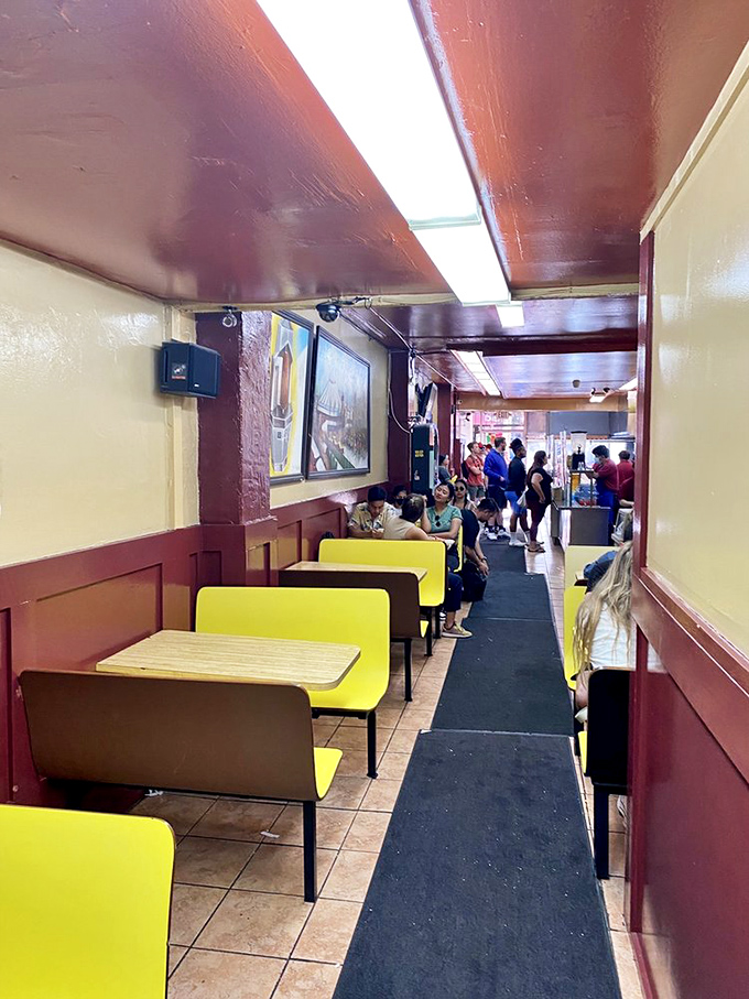 The narrow corridor of yellow booths fills with pilgrims on the burrito path, all united in the universal language of "mmmmm."