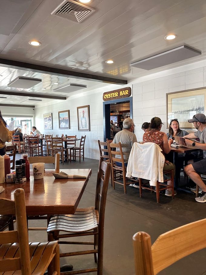 The oyster bar sign promises briny treasures within. Diners gather like seafood pilgrims at this shrine to shellfish satisfaction.