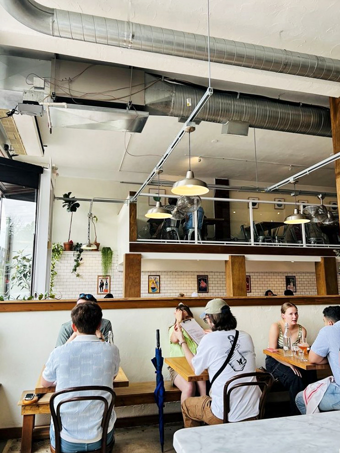 The dining room hums with conversation and anticipation, while exposed ductwork and subway tiles create the perfect backdrop for pizza appreciation.
