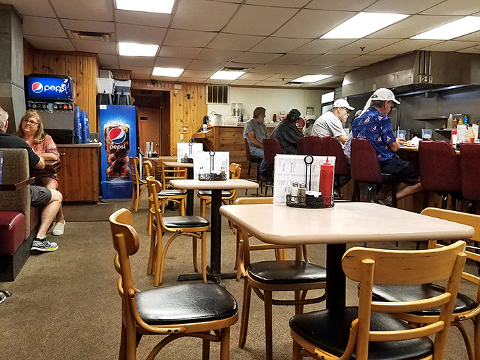 Where tables become community gathering spots and strangers become neighbors over coffee and conversation. The Pepsi machine stands guard like a loyal sentinel.
