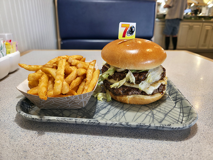 A burger that requires jaw exercises beforehand, served with a side of golden fries that crunch like autumn leaves.