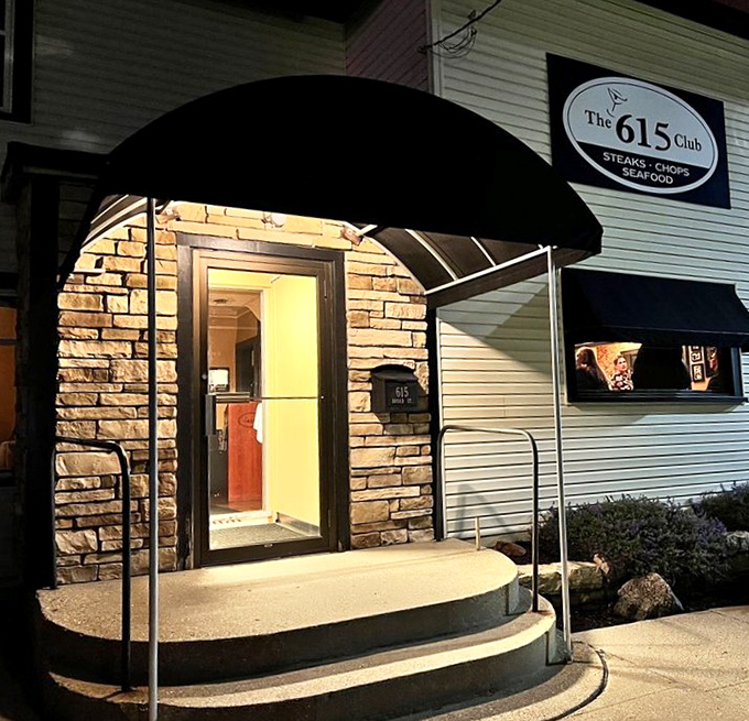 That illuminated entrance beckons like a lighthouse for hungry souls. The black awning adds just the right touch of mid-century elegance.