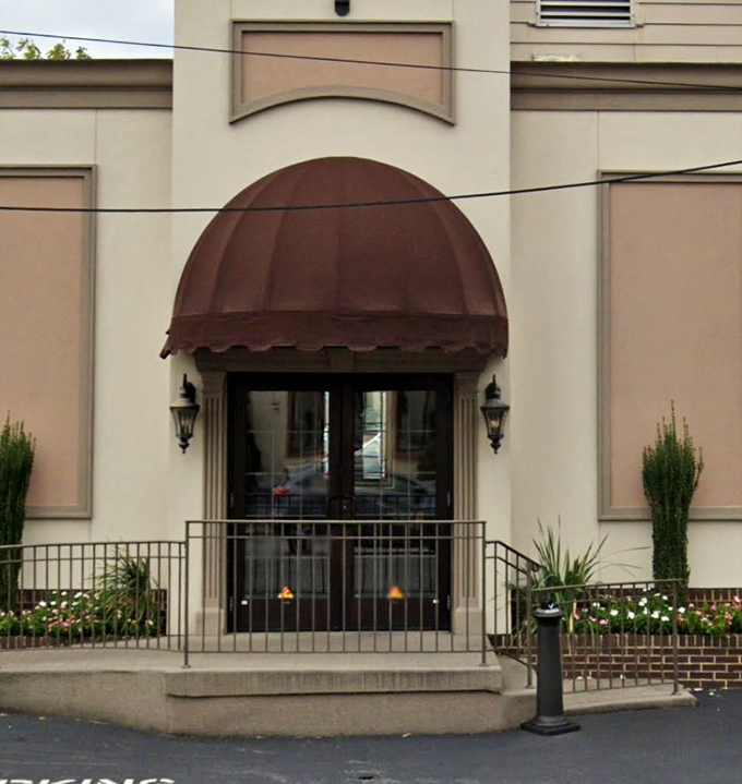 The entrance beckons with its burgundy awning and warm lighting, like a culinary hug waiting to happen