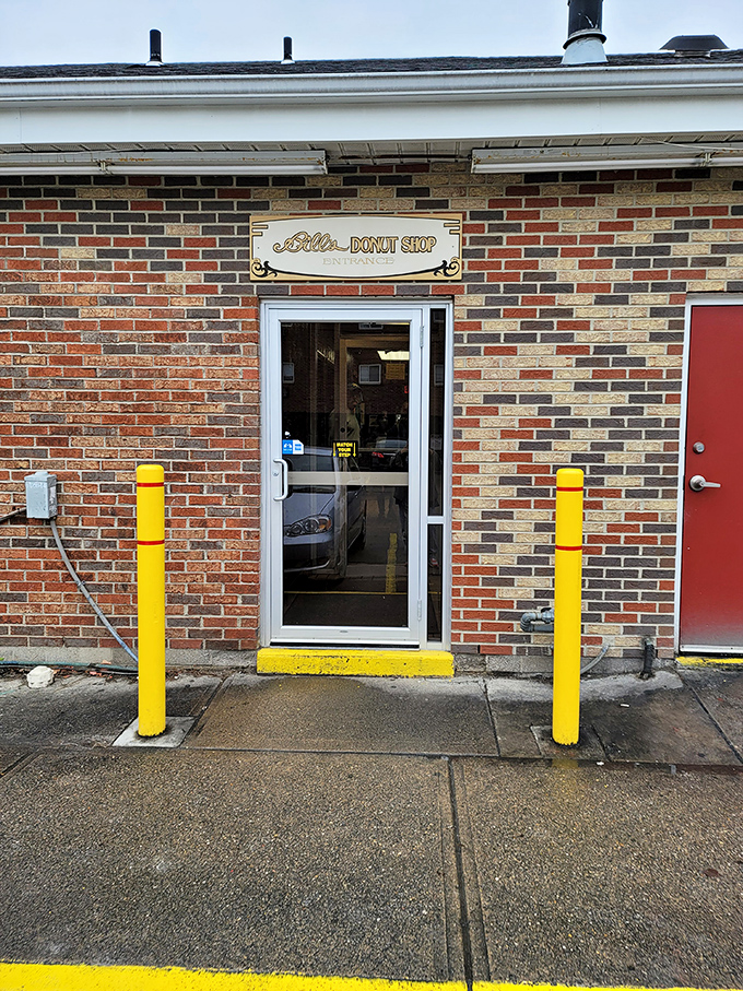 Two yellow bollards stand guard at the entrance, protecting Ohio's donut treasure like sentinels of sweetness.