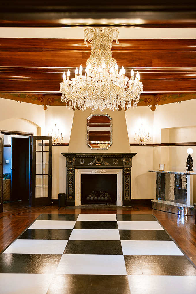 The checkerboard floor practically demands a human-sized chess match, while that chandelier has probably witnessed more than a few grand entrances.