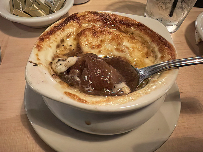 French onion soup with a cheese cap so perfect it deserves its own security detail. Comfort in a crock, one spoonful at a time.