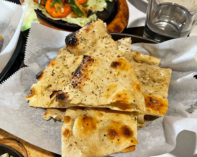 Garlic naan with those perfect char marks—the ideal edible utensil for scooping up every last drop of that magnificent sauce.