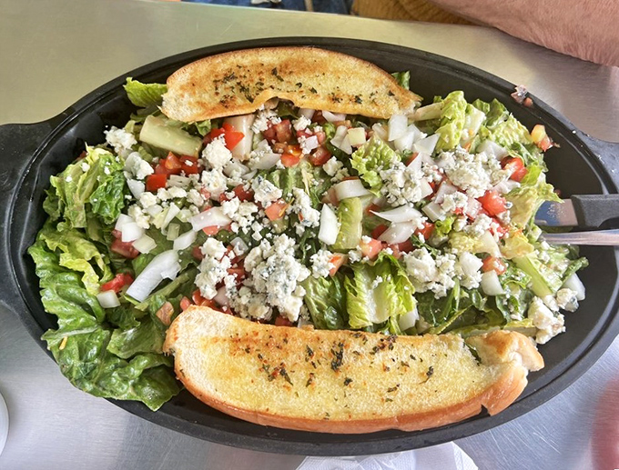 A Gorgonzola salad that could convert carnivores. Fresh romaine cradles a mountain of veggies and cheese between slices of garlic bread.