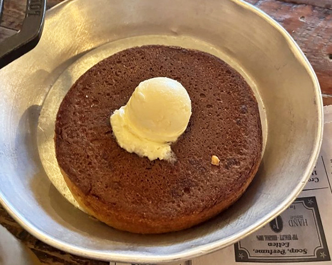 This griddle cake isn't just breakfast; it's a warm hug on a plate, complete with a butter pat slowly melting into its golden embrace.