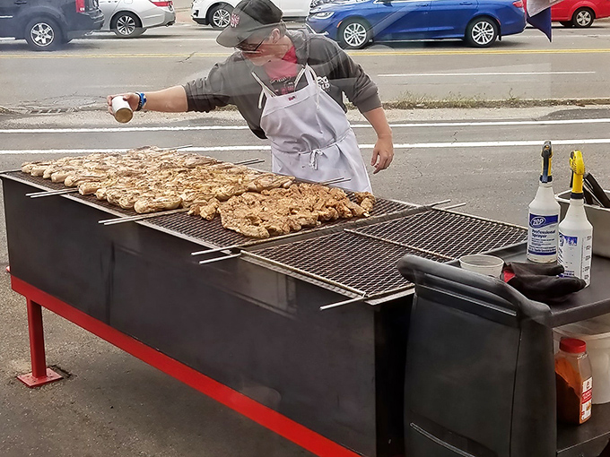 Chicken sizzling on the outdoor grill, tended by careful hands. This isn't just cooking&mdash;it's a public performance art where smoke signals announce deliciousness is imminent.