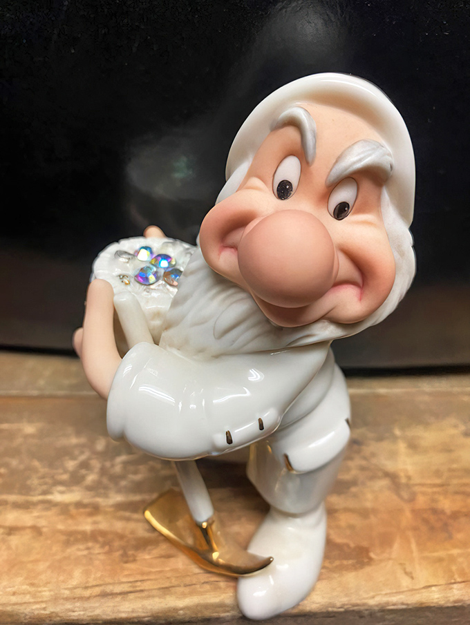 This cheerful porcelain dwarf figurine seems suspiciously happy&mdash;probably because he knows he's about to become someone's quirky bookshelf guardian.