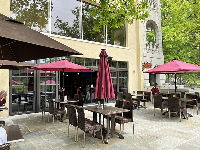 Outdoor dining under burgundy umbrellas creates the perfect setting for conversations that linger longer than the meal itself.