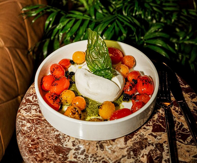 Burrata surrounded by colorful tomatoes like a creamy island in a vibrant sea. Summer captured in a bowl.
