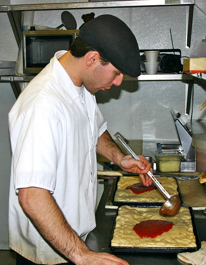 Behind the scenes, the pizza-making process reveals itself as part science, part art, and all tradition&mdash;each tray built with practiced precision.