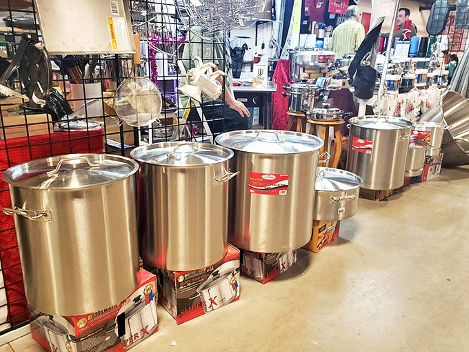 Industrial-sized cookware lined up like soldiers ready for culinary battle. These pots have seen things your home kitchen couldn't imagine.