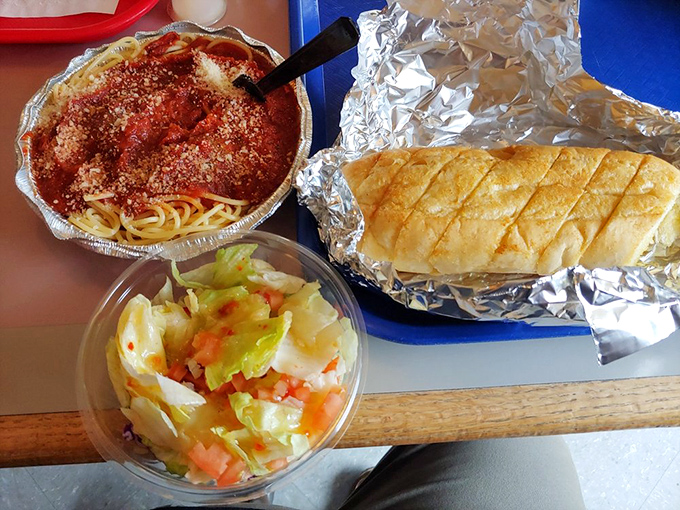 A perfect Italian trinity: spaghetti with generous parmesan, garlic bread for sauce-sopping, and a fresh salad pretending this meal has nutritional balance. 