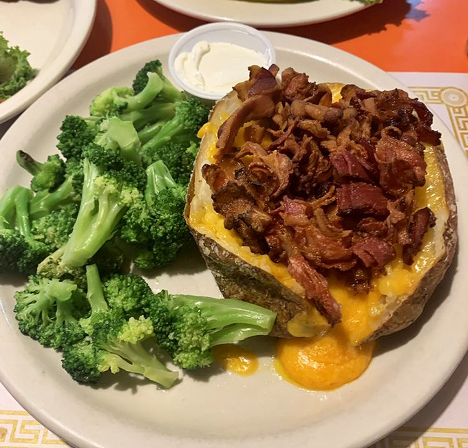 A loaded baked potato that's dressed better than most people at the mall – cheese, bacon, and broccoli for that token vegetable.