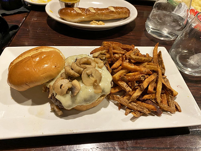A burger that requires both hands, several napkins, and possibly a nap afterward. Those mushrooms aren't just toppings&mdash;they're a commitment to excellence.