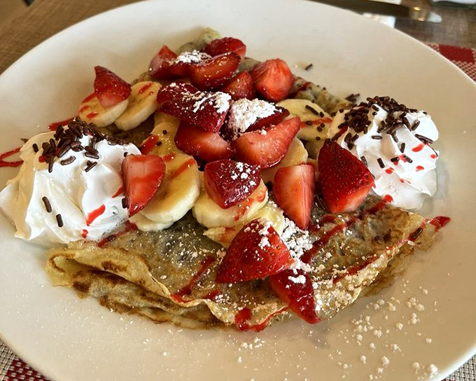 These crepes don't just display fruit—they celebrate it. Strawberries, bananas, and whipped cream creating a breakfast that's both indulgence and art.