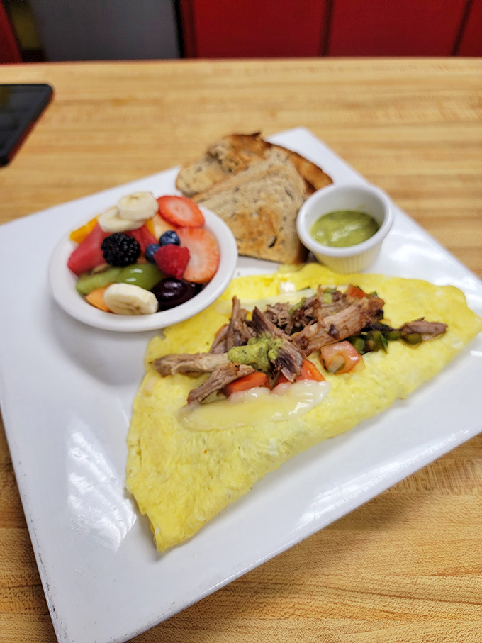This omelet doesn't just contain ingredients—it showcases them, with a side of fresh fruit that's practically waving hello.