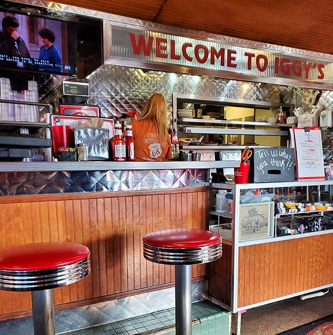 The counter where dreams come true, one order at a time. That Route 66 shirt isn't just merch&mdash;it's a uniform of American culinary heritage.