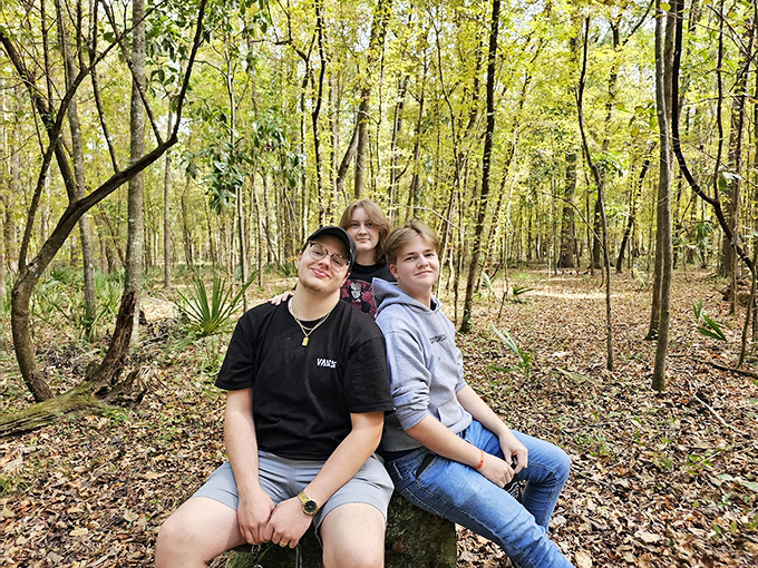 The forest provides a natural backdrop for creating lasting memories. These visitors found the perfect spot for a family photo without a beach in sight.
