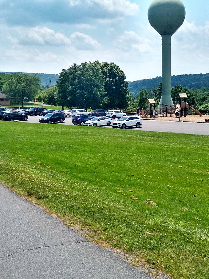 The water tower stands sentinel over the parking area. Even practical infrastructure looks picturesque when framed by Pennsylvania's rolling hills.