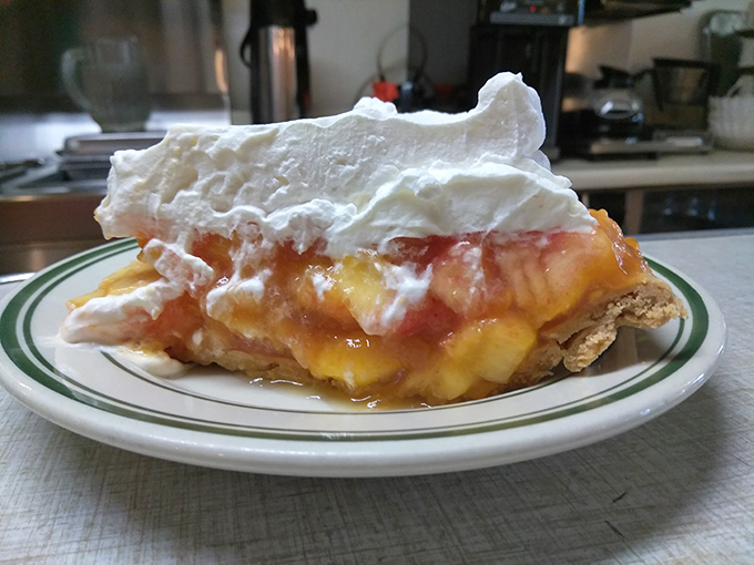 Peach pie that captures summer in every bite, crowned with whipped cream that's practically begging for its own Instagram account.
