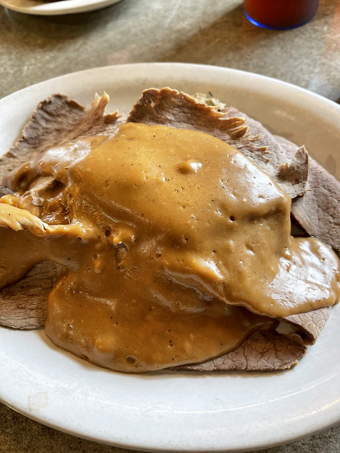 Roast beef draped in gravy like it's wearing a velvet robe. This isn't just dinner&mdash;it's a brown gravy spa treatment.