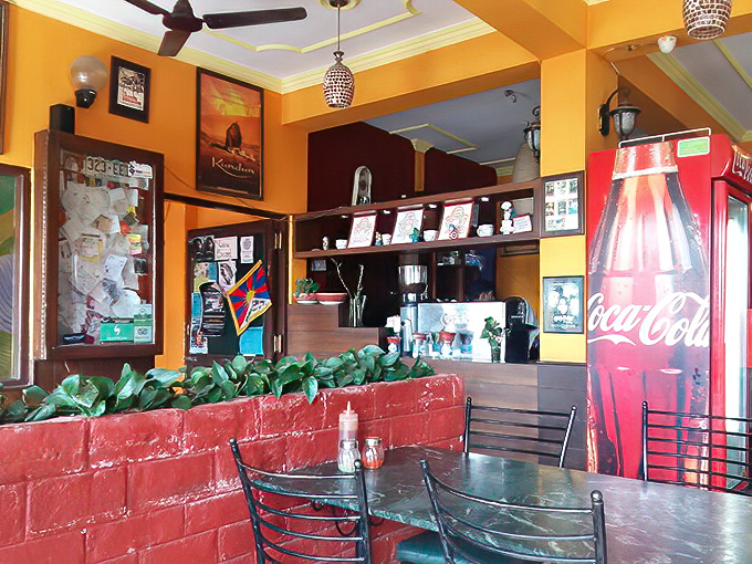 Bright yellow walls and red brick create a cheerful command center where coffee brews, orders flow, and the staff orchestrates your Italian food fantasies.