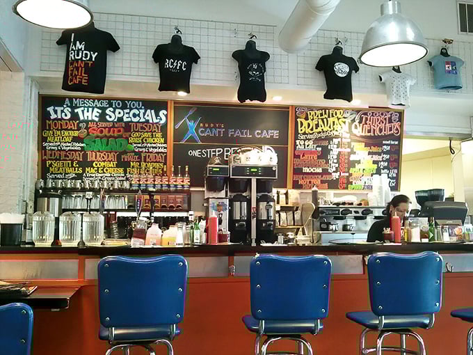 T-shirts hang like trophies above the counter, while the rainbow-colored menu boards promise breakfast salvation to hungry patrons.