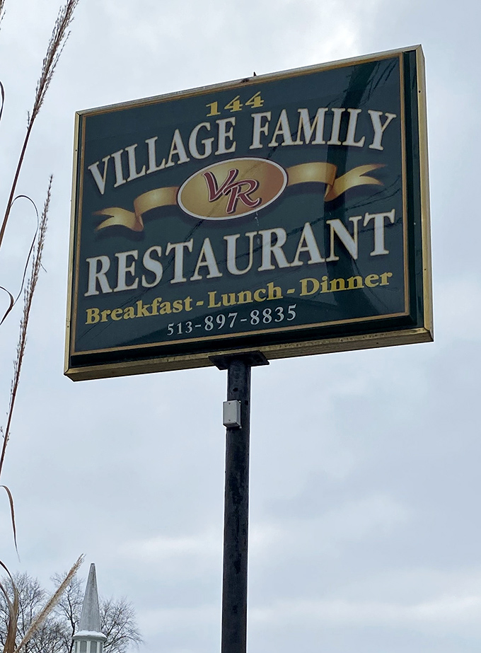 The roadside sign stands as a beacon of hope for hungry travelers, promising three square meals and zero pretension just off the highway.