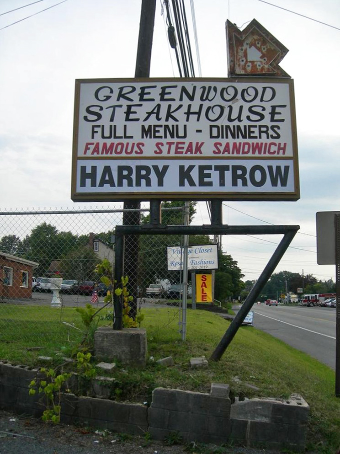 The roadside sign stands like a beacon of hope for hungry travelers—"FAMOUS STEAK SANDWICH" isn't marketing; it's just stating facts.