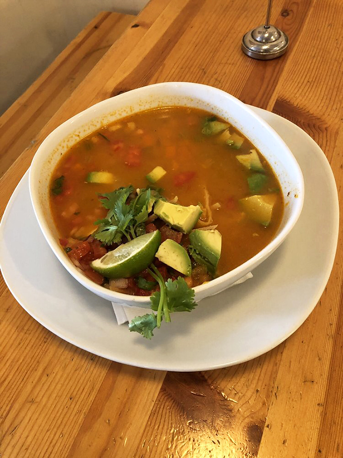 This sopa de tortilla isn't just soup—it's a warm hug in a bowl, topped with fresh avocado islands and a lime wedge lifeboat.