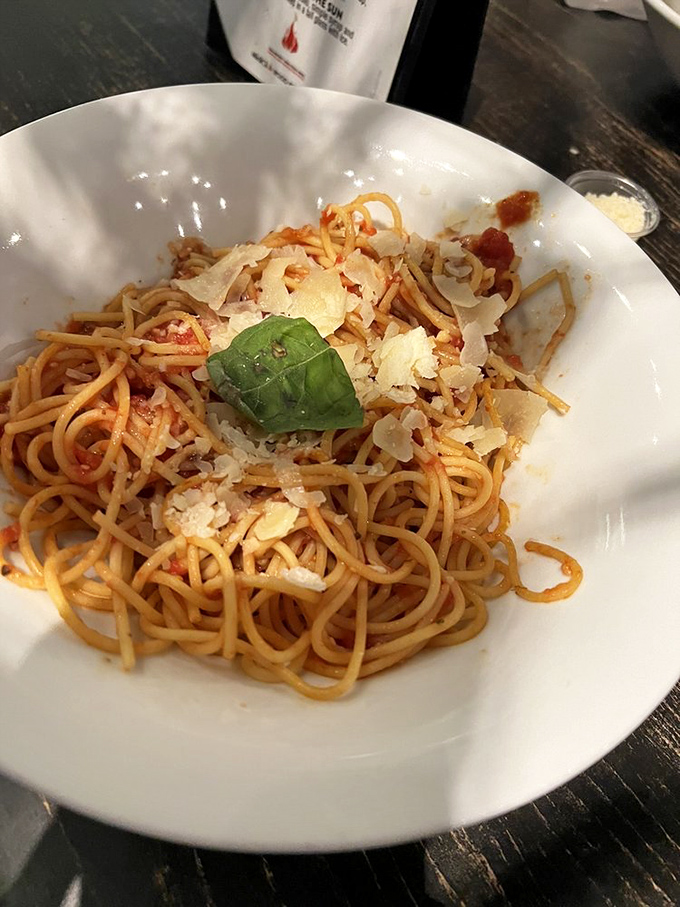 Spaghetti so perfectly cooked it practically twirls itself around your fork. That single basil leaf is the crown jewel.