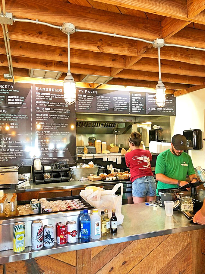 Behind the counter, culinary magic happens with practiced efficiency. These aren't just staff members; they're seafood artists working their craft.