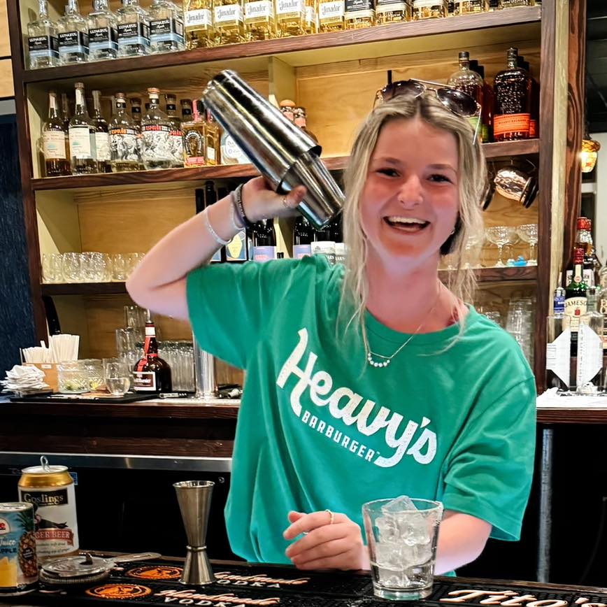 The magic happens when passion meets cocktail shaker. That smile says, "This drink is about to change your afternoon."