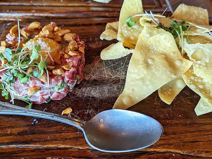 Steak tartare that dares you to live a little. Topped with a golden egg yolk and served with impossibly thin chips &ndash; raw sophistication on a wooden board.