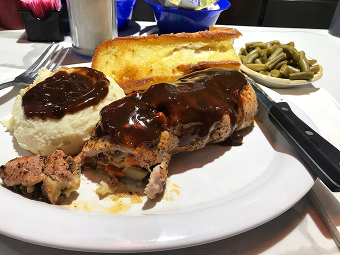 Meatloaf smothered in gravy with sides of mashed potatoes and green beans—a plate that whispers, "Take a nap after this."