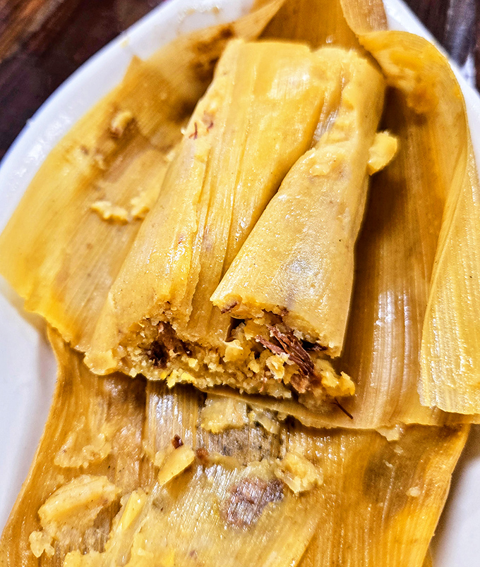 Tamales wrapped like precious gifts, revealing savory treasures within. Unwrap slowly&mdash;this moment deserves your full attention.