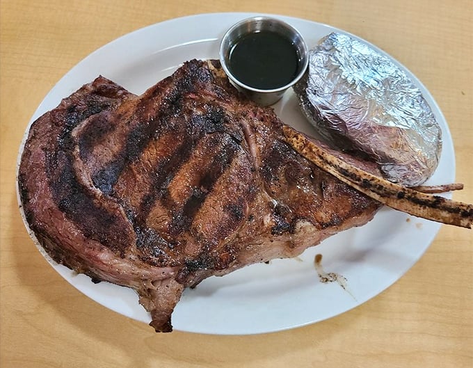 This isn't just a steak; it's a prehistoric-looking tomahawk that Fred Flintstone would approve of, complete with au jus for dipping.