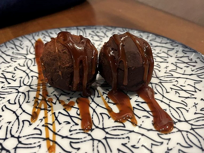 Chocolate truffles drizzled with caramel that look like they escaped from a dessert fantasy. Two perfect bites that make you seriously consider ordering another round.