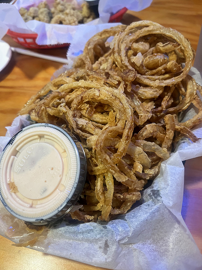 Onion straws piled higher than your weekend to-do list. Crispy, golden tangles that make regular onion rings look like underachievers.
